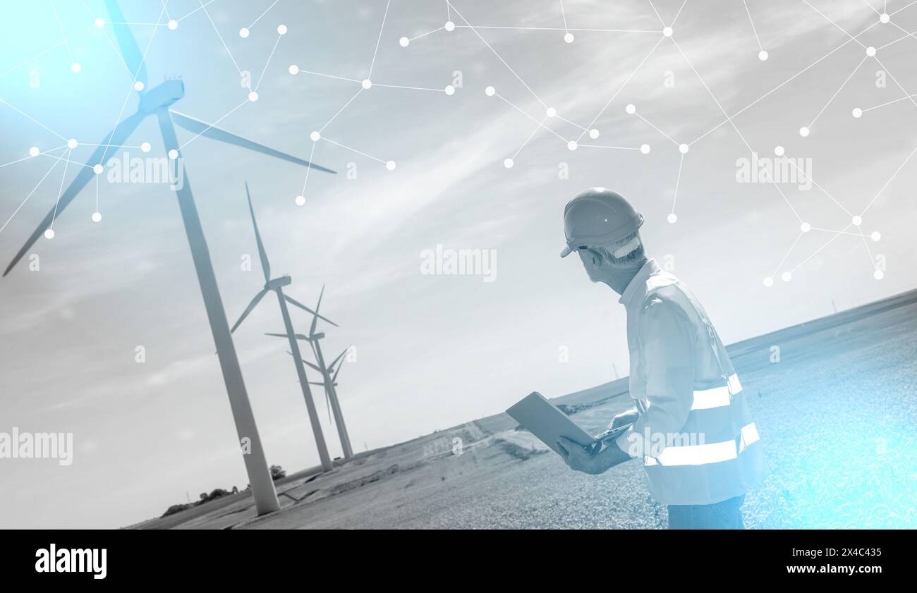 Electrical engineer using laptop for wind turbine inspection; light ...