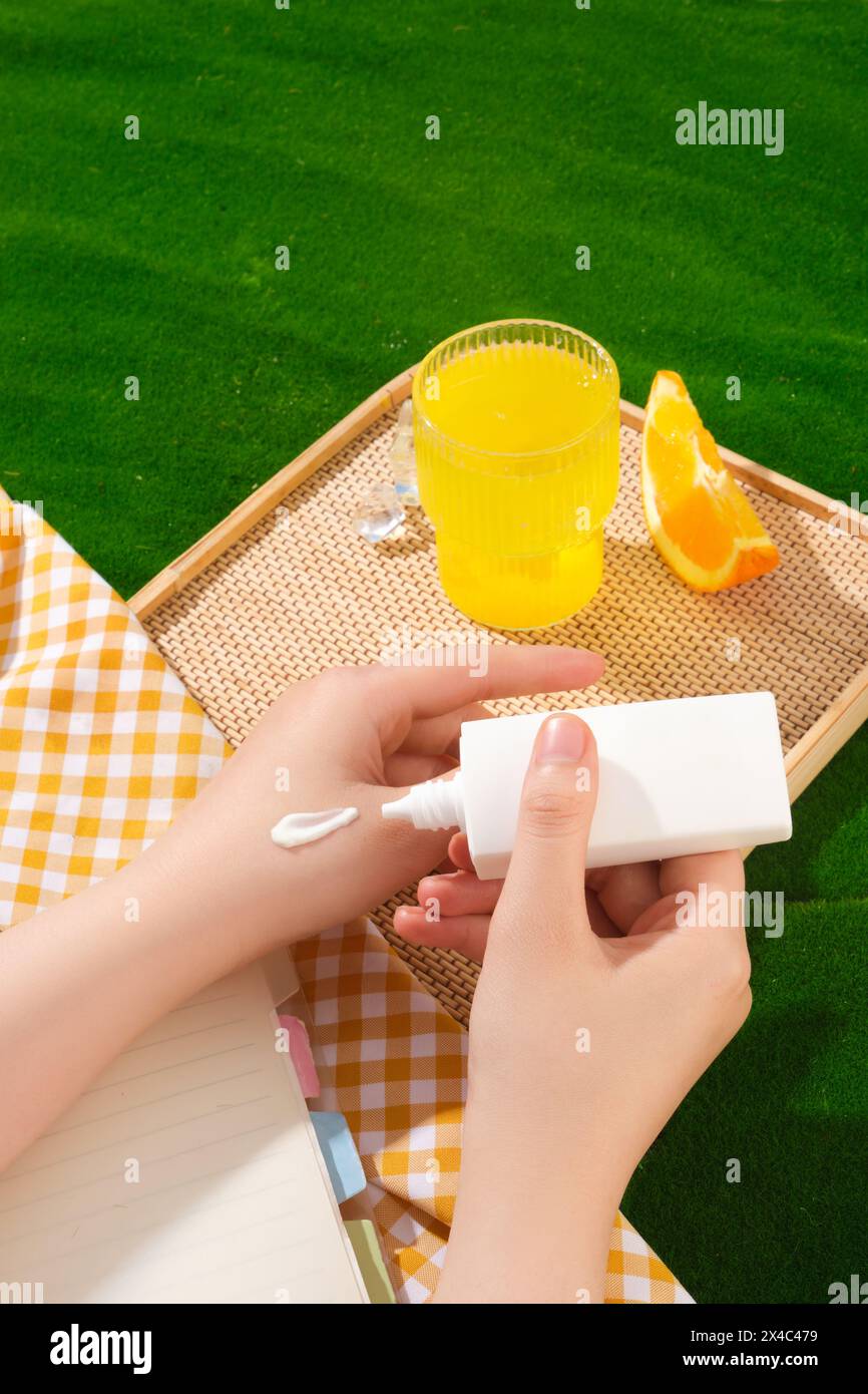 Protect from the sun. A woman applies sunscreen on the back of her hand ...