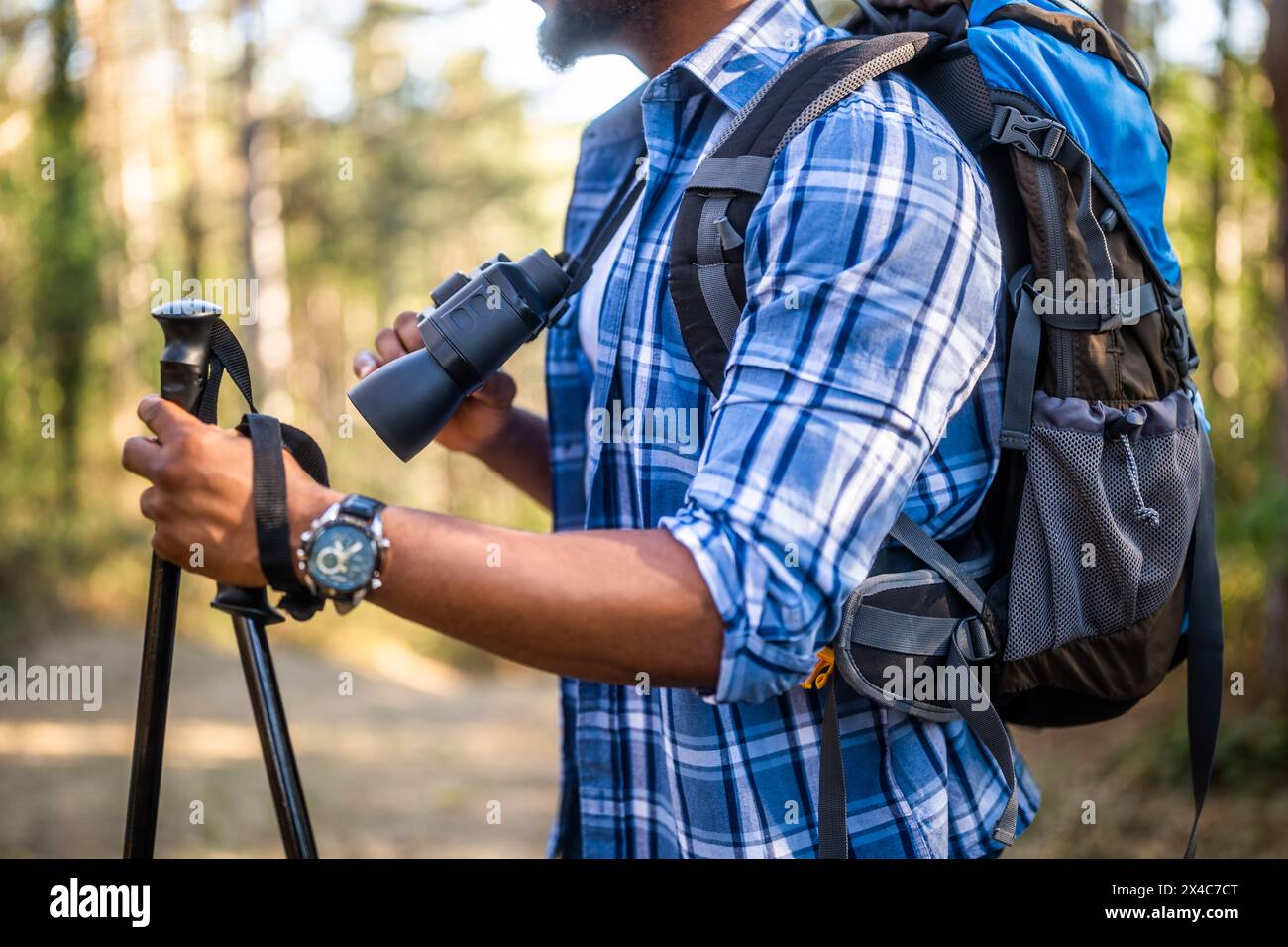 Young man enjoys using binoculars and hiking in nature Stock Photo - Alamy