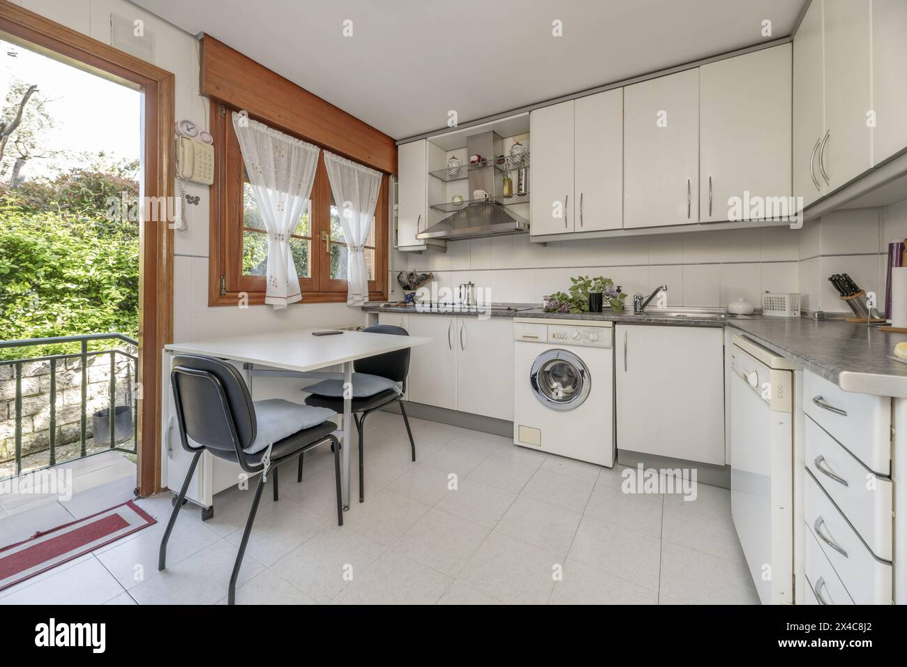 Frontal image of a kitchen with white furniture with metal handles ...
