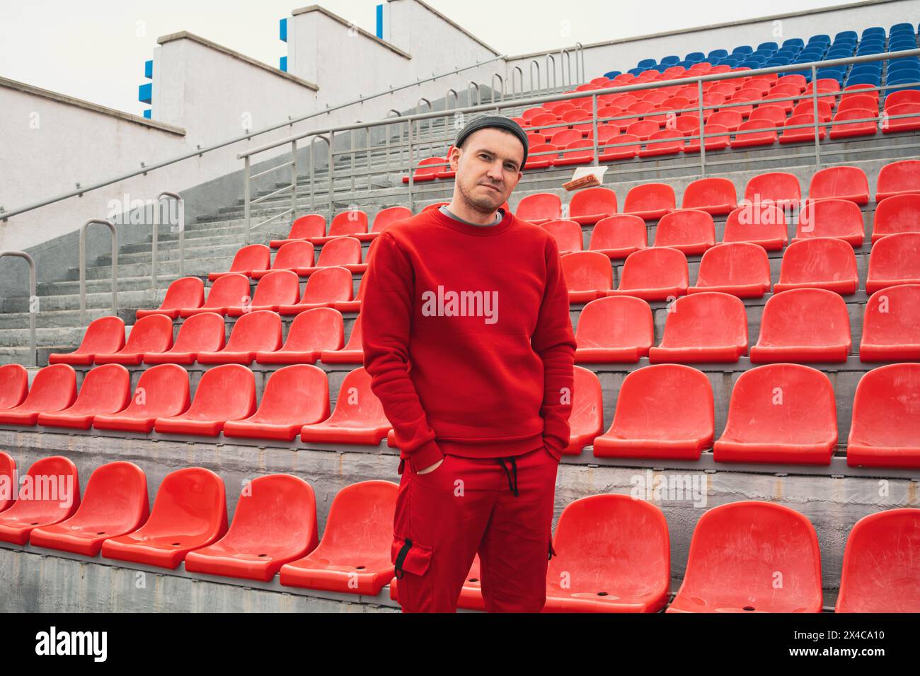 Man Standing in Front of Empty Stadium. A man stands alone in front of ...