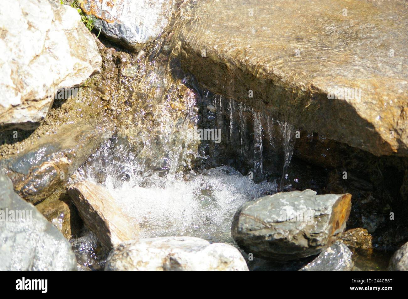 Clear water running over rocks in the sunlight Stock Photo - Alamy