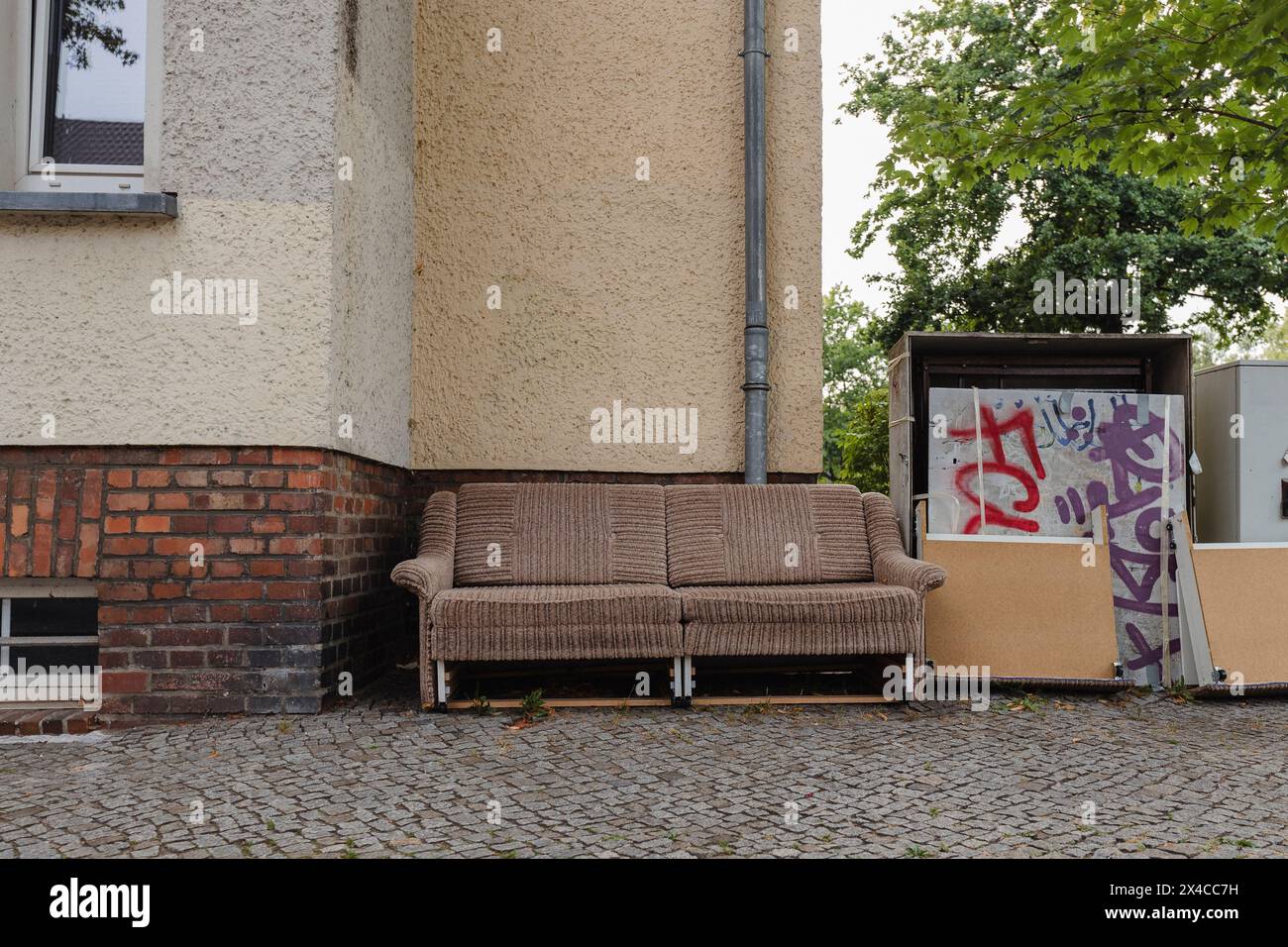 An old couch left on the sidewalk, bulky waste on the street, bulky ...
