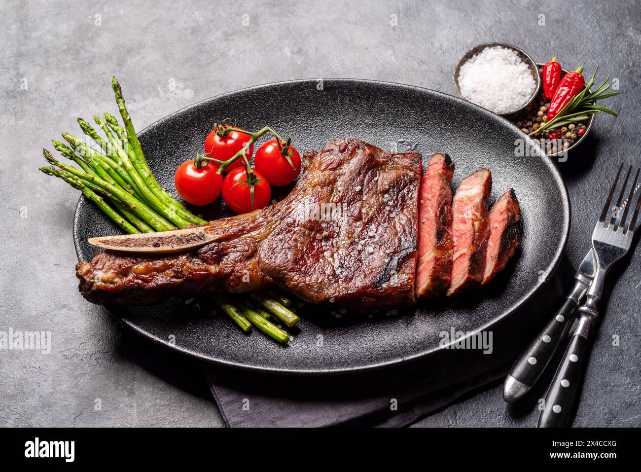 Medium rare grilled Tomahawk beef steak with asparagus on plate Stock ...