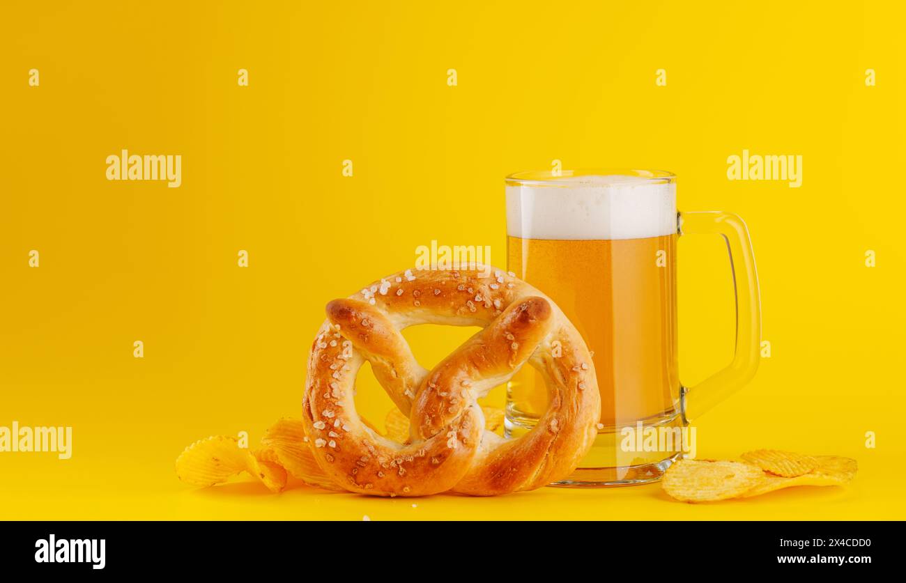 Beer, chips and pretzel. Over yellow background with copy space Stock ...