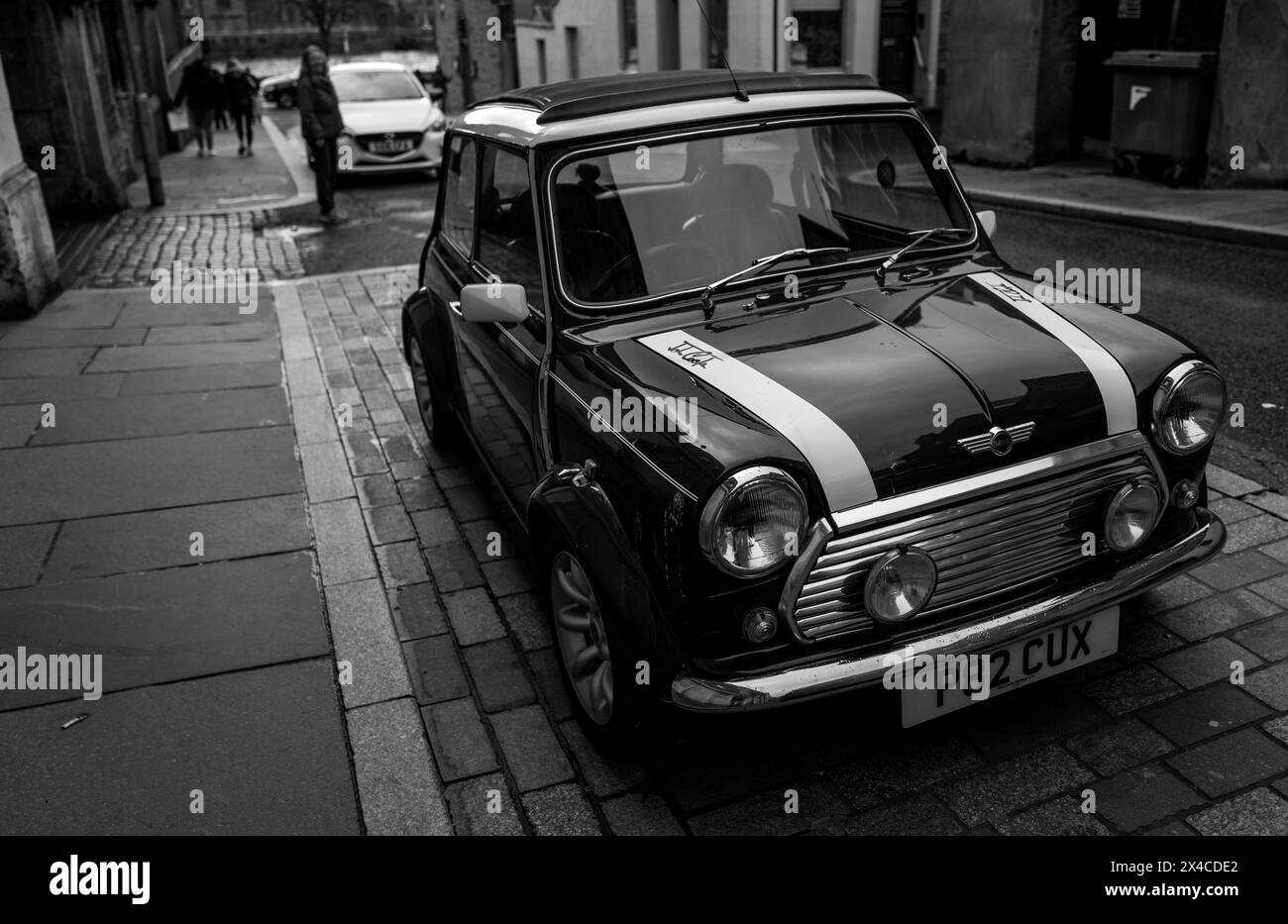John Cooper mini cooper S in black with white strips parked on a cobble ...