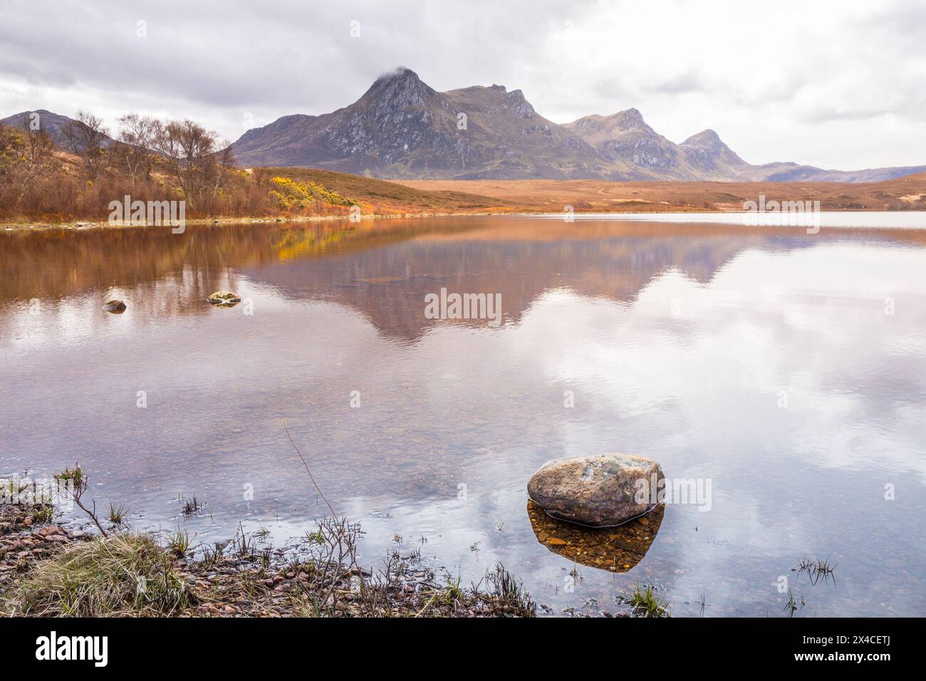 The mountain range of Ben Loyal reflected in the still waters of Lochan ...