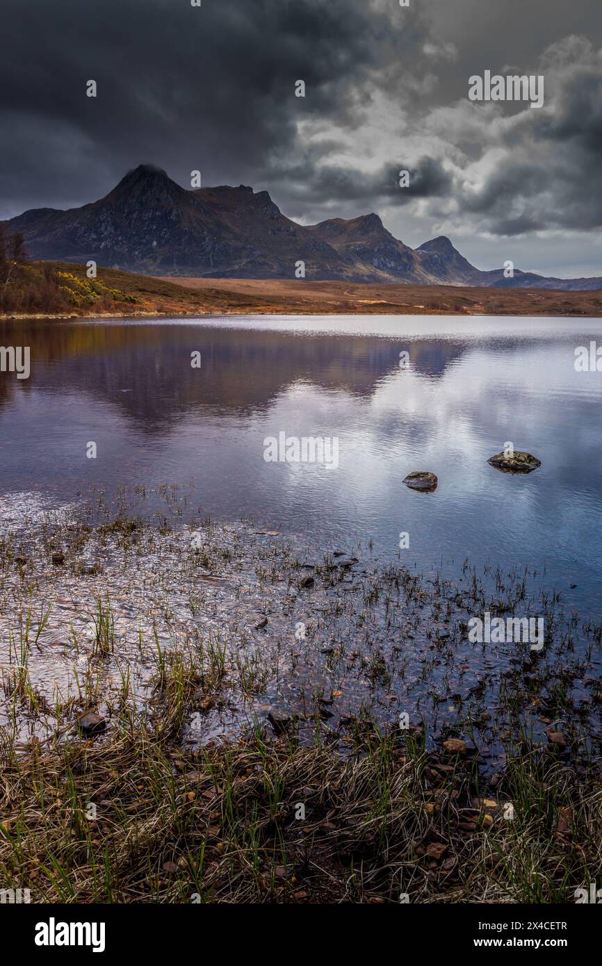 The mountain range of Ben Loyal reflected in the still waters of Lochan ...
