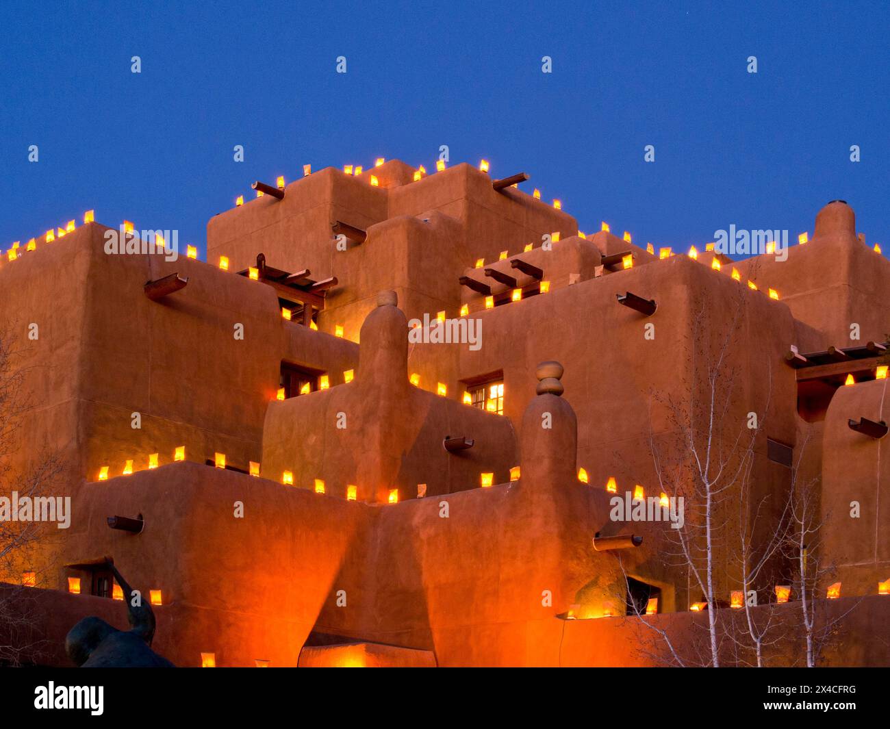 USA, New Mexico, Sante Fe. Luminaries light up a hotel at night in ...