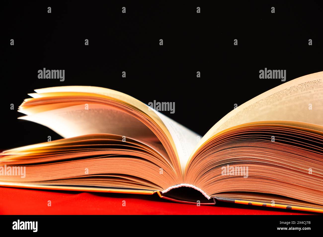 Pages of a thick book are turned on a red and black background Stock ...