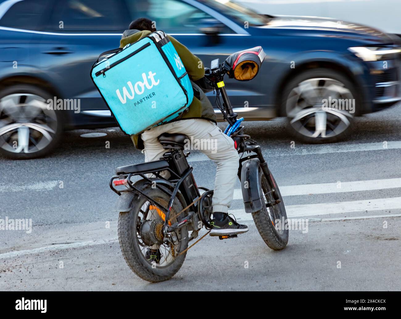 Wolt food delivery bike courier waiting at a red light in Sörnäisten ...