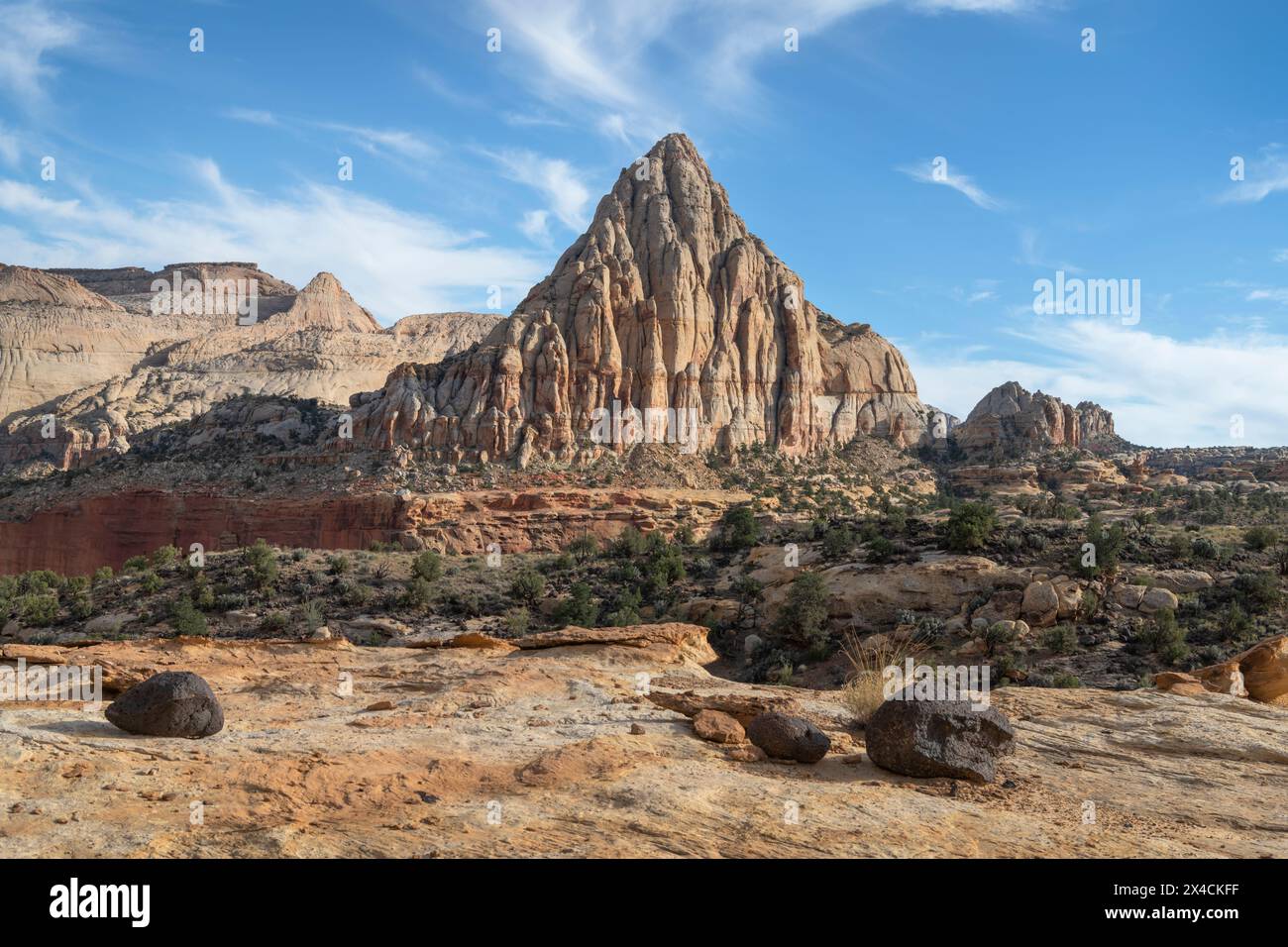 Pectols pyramid and black lava boulders on striated sandstone slickrock ...