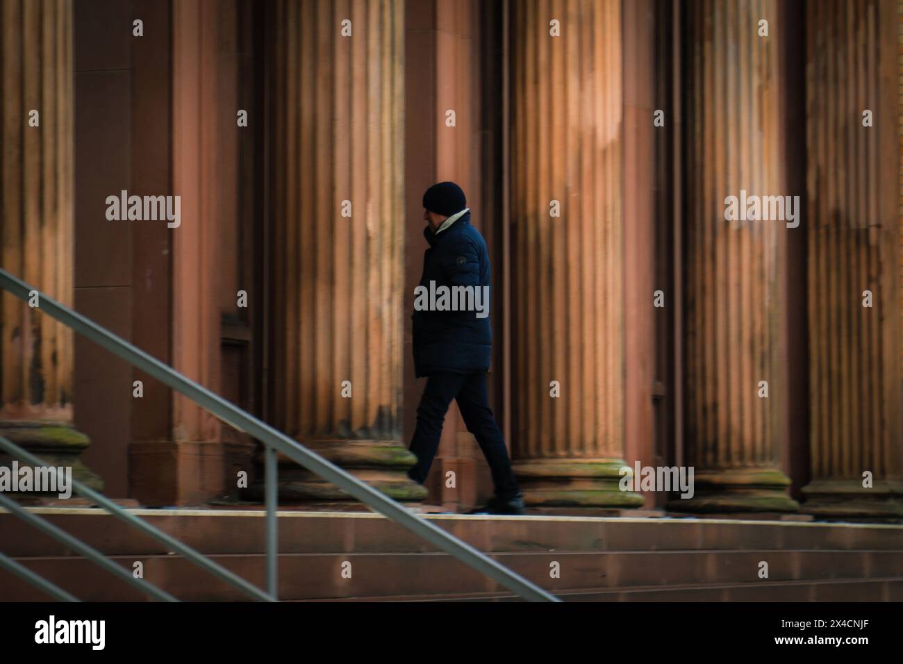 Amidst the grandeur of towering columns, men stroll, their figures ...