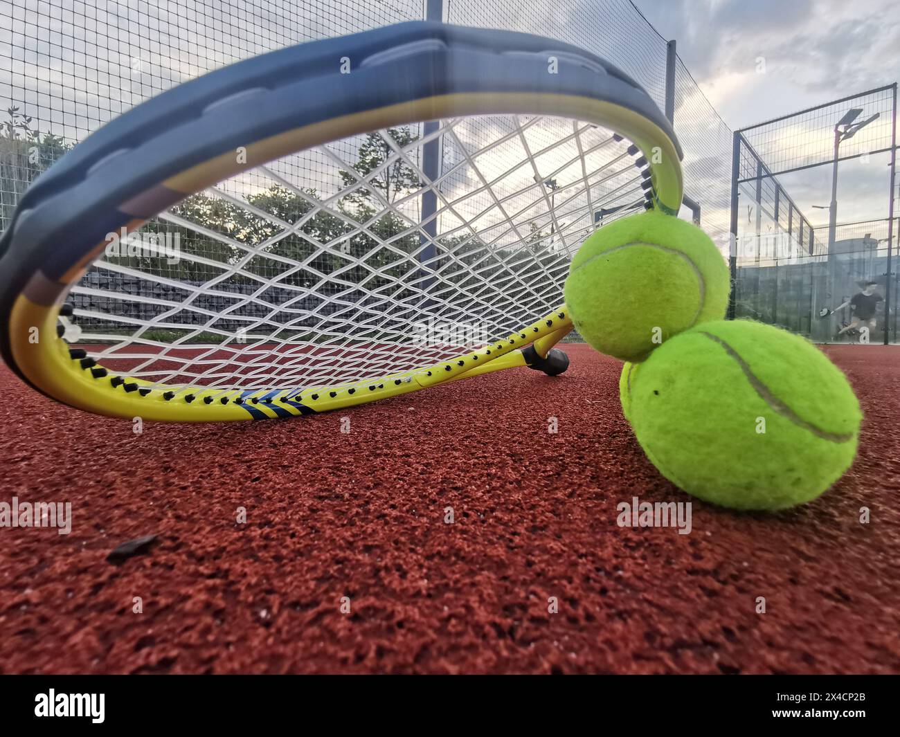 yellow tennis balls and racquet on hard tennis court surface, top view ...