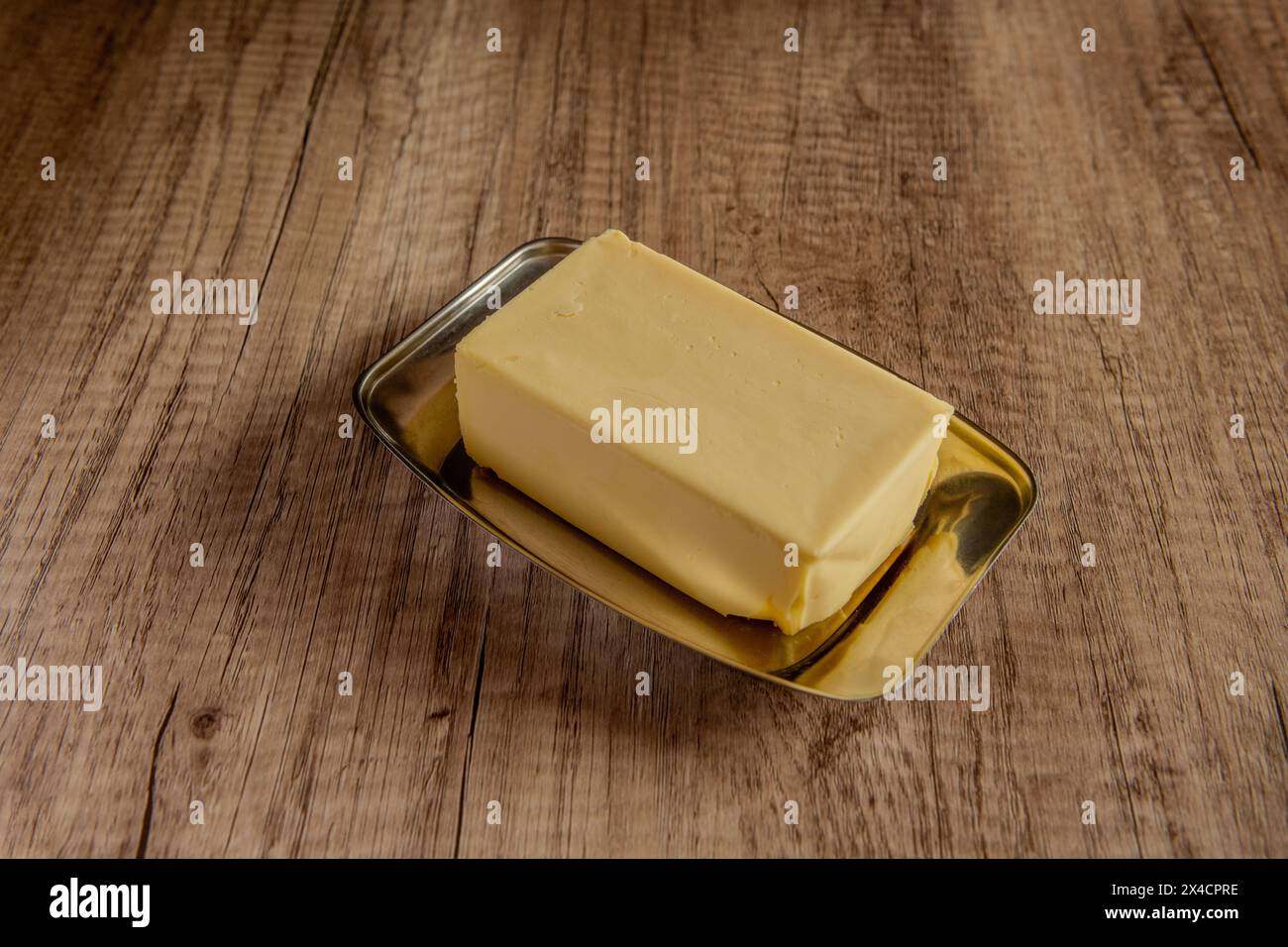 A slab of butter on a butter dish with a wooden background Stock Photo ...