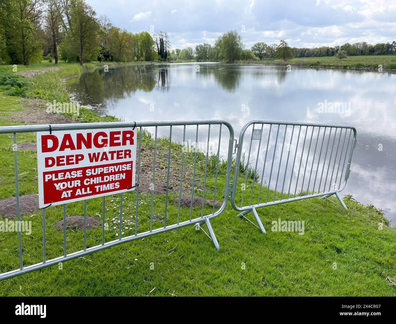 Crowd barriers have been placed by a lake to prevent access and a sign ...