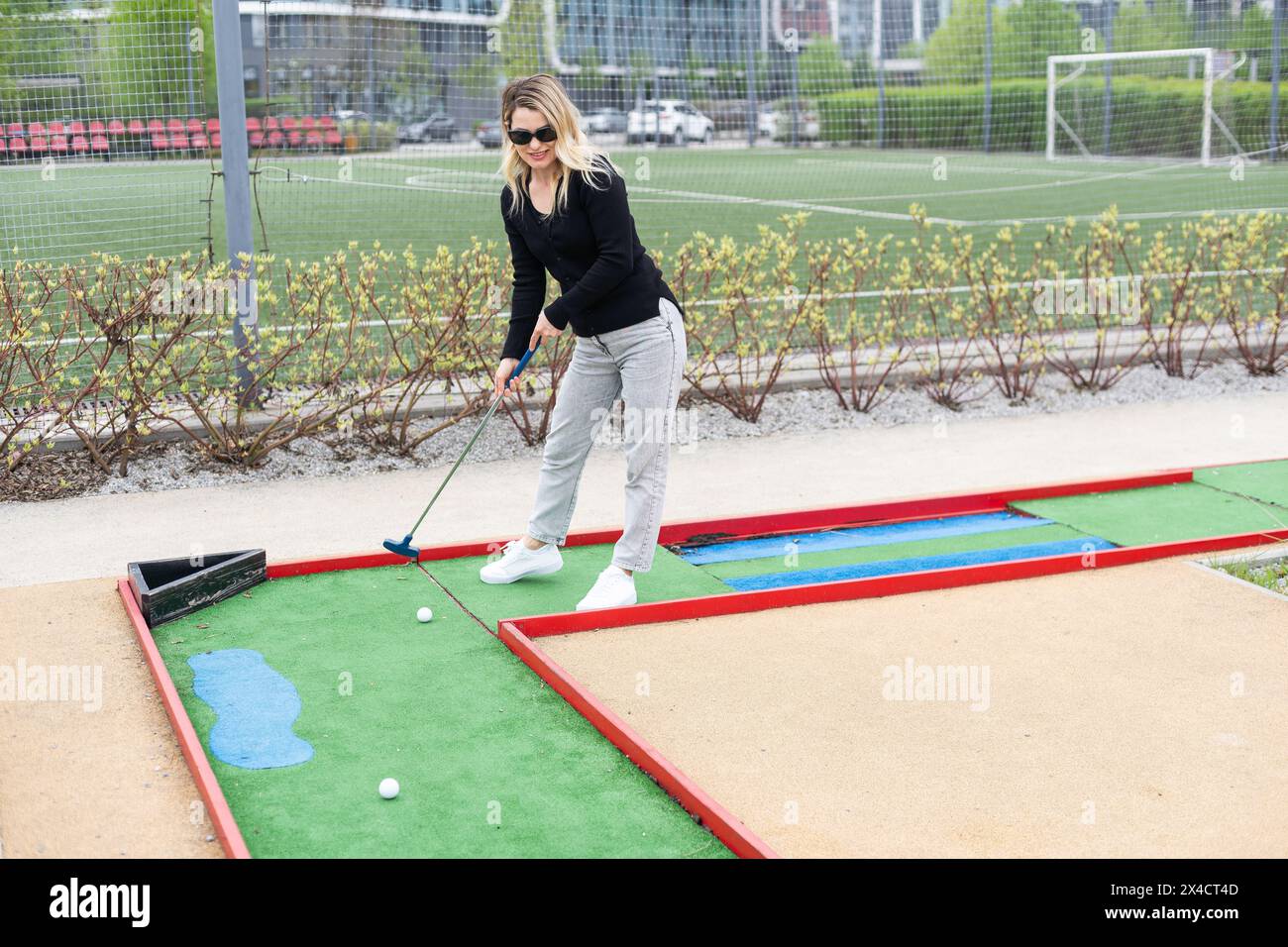 Playing Adventure Golf, downhill shot, ball, club and hole Stock Photo ...