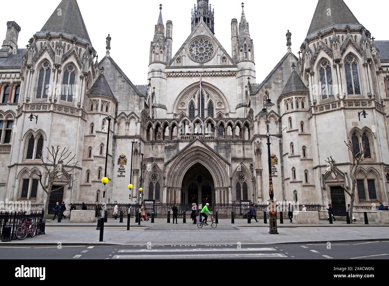 Outside view of people and cyclist in street outside the Royal Courts ...