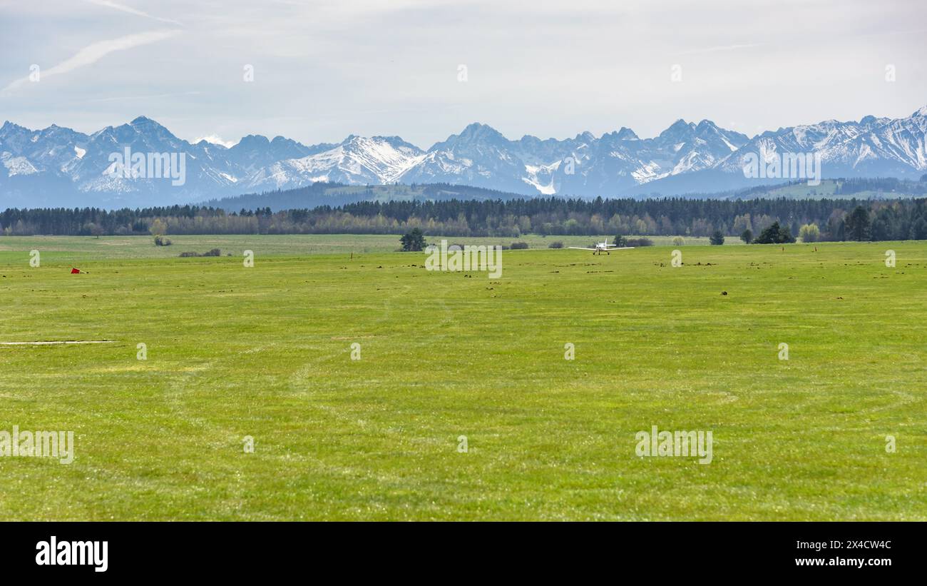Small airplane on the sport grass airfield in Nowy Targ. Tatra mountain ...