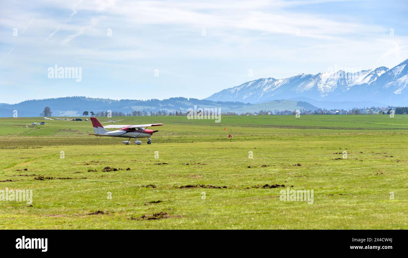 Small airplane on the sport grass airfield in Nowy Targ. Tatra mountain ...