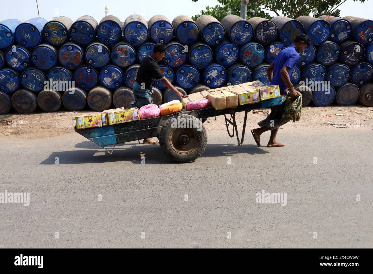 Dhaka, Dhaka, Bangladesh. 2nd May, 2024. Workers are transporting goods in a two-wheeled cart at ...
