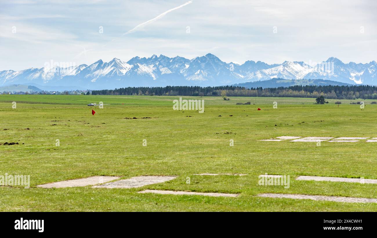 View of snow capped Tatra mountains from sport grass airfield in Nowy ...