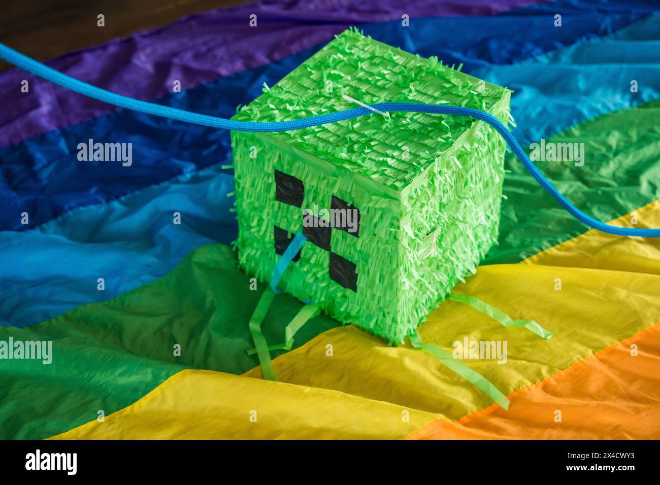 Green cube pinata in pixel craft style on rainbow background for kids ...