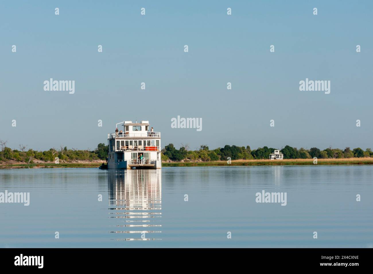 A boat full of tourists exploring the Chobe River, Chobe National Park ...