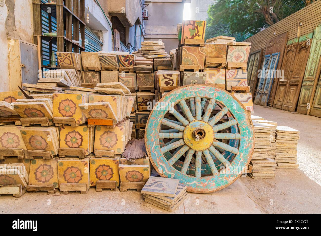 Old Cairo, Cairo, Egypt. Wooden cart wheel and floor tiles in an alley ...