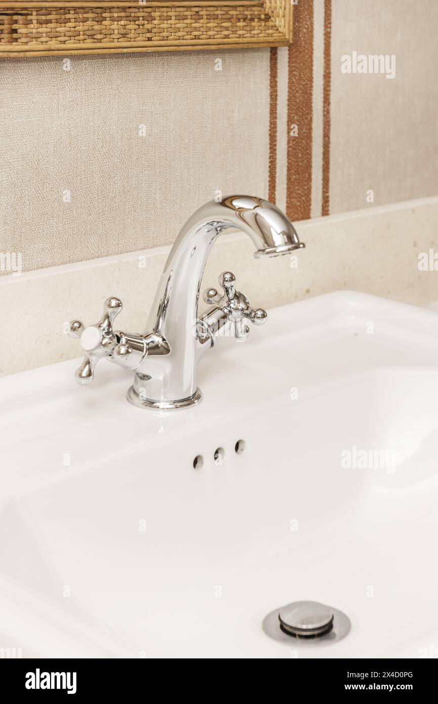 White porcelain sink on a cream marble countertop with a vintage-style ...