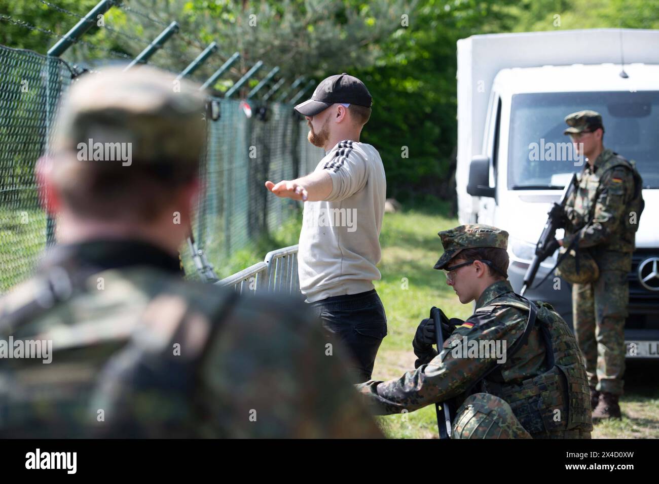 Darstellung: Soldaten bewachen und durchsuchen einen Verdaechtigen ...