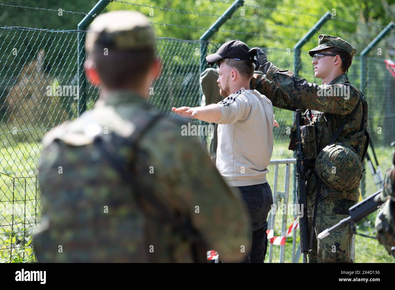 Darstellung: Soldaten bewachen und durchsuchen einen Verdaechtigen ...