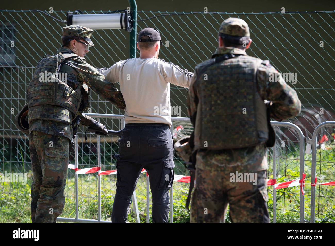 Darstellung: Soldaten bewachen und durchsuchen einen Verdaechtigen ...