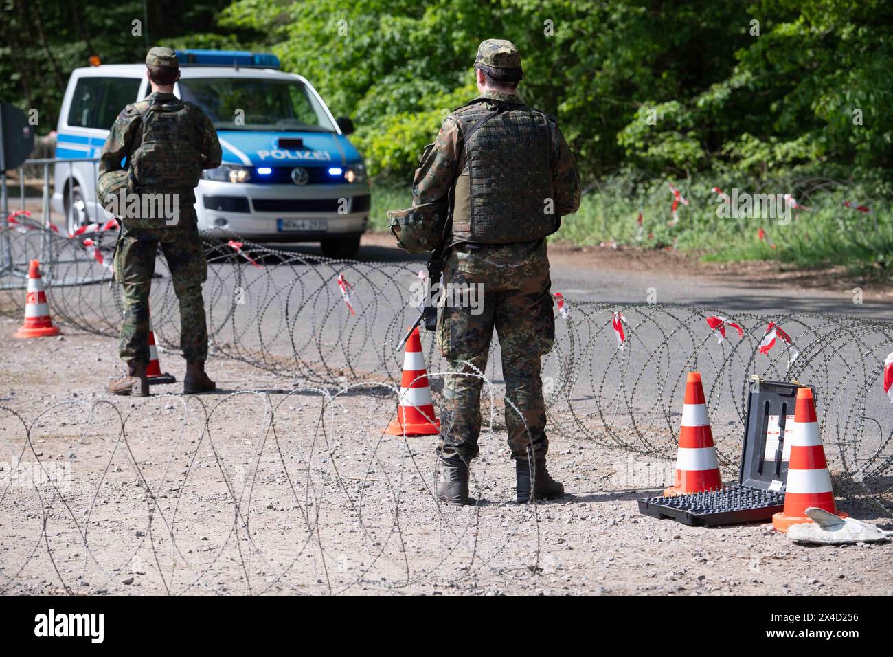 Ein Polizeifahrzeug kommt zur Fahrzeugschleuse, Sperre aus Stacheldraht ...