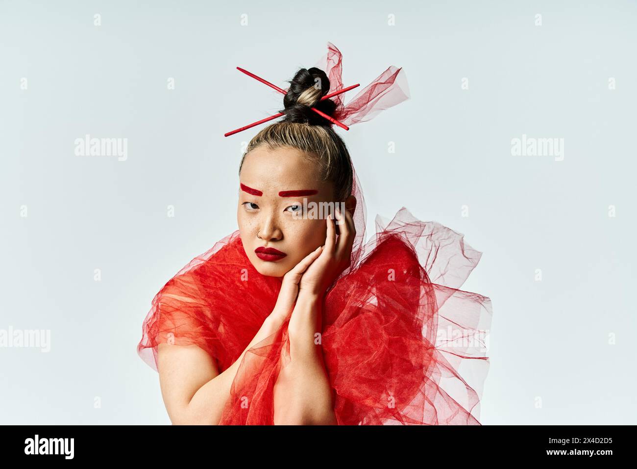 Asian woman in red dress, hands on face Stock Photo - Alamy