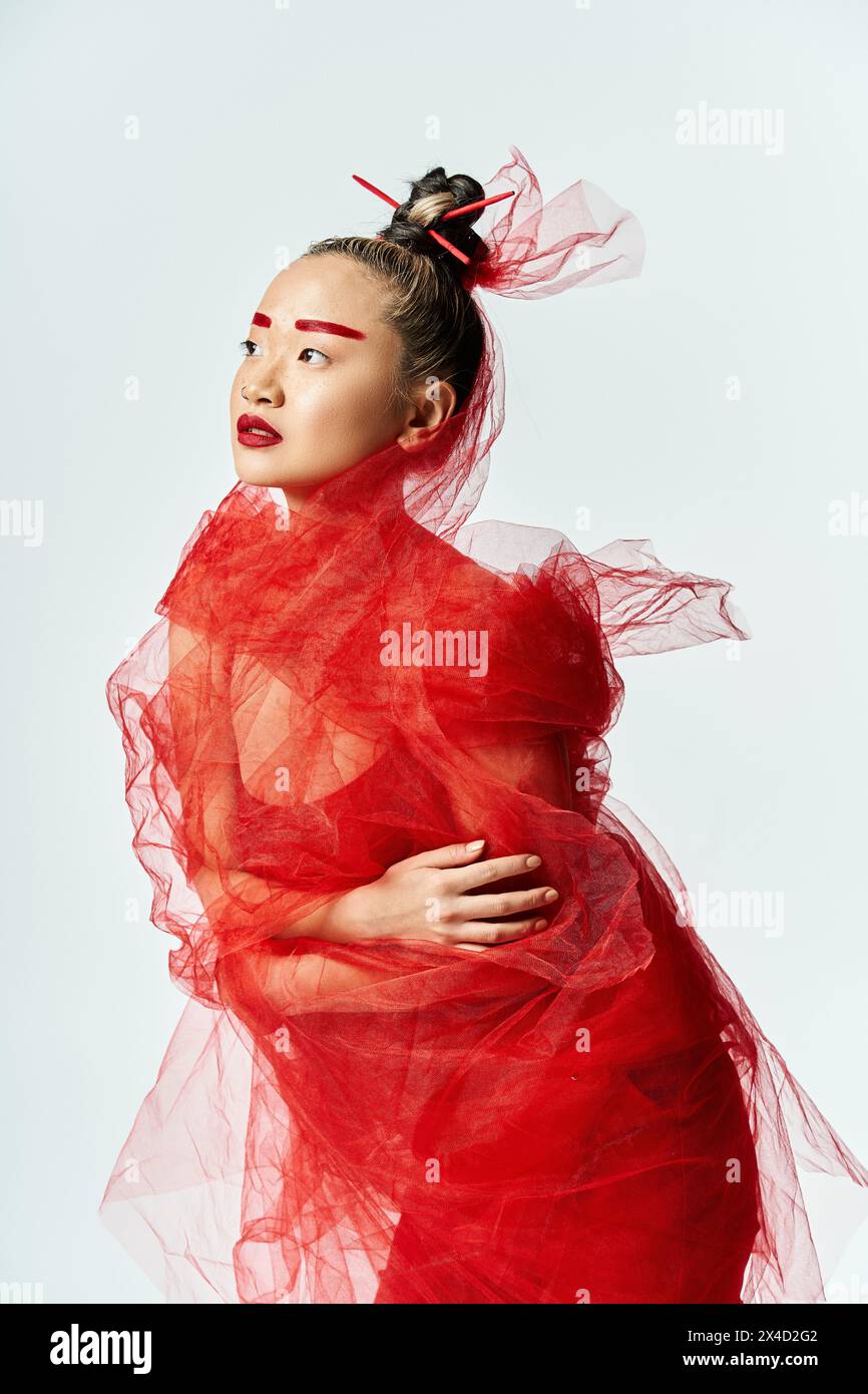 Captivating Asian woman strikes a graceful pose in a vibrant red dress ...