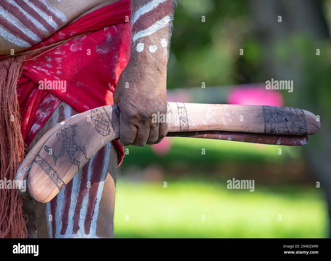 Human hand holds ritual clapsticks for the welcome ritual rite at an ...