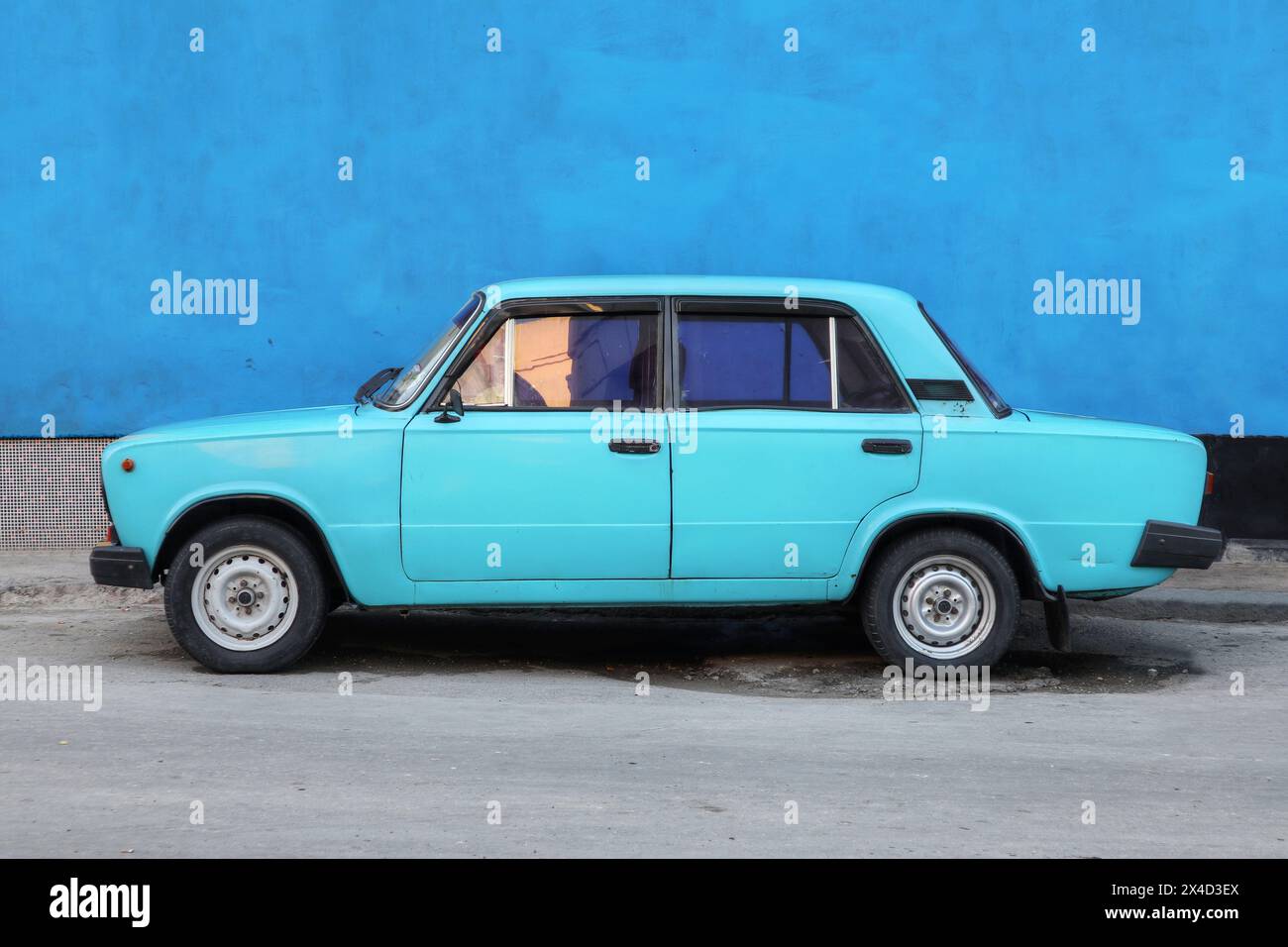 A Monochrome photo of a blue car in front of a blue wall in Havana Cuba ...
