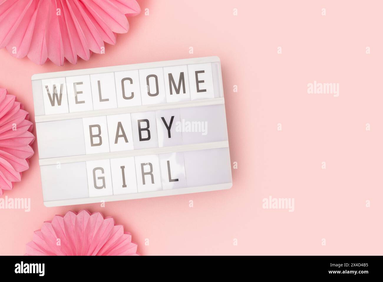 Welcome baby girl. Lightbox with letters and tissue paper fans in a ...