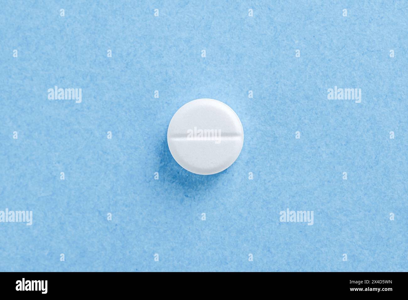 White tablet pill on blue background with copy space. Health concept ...