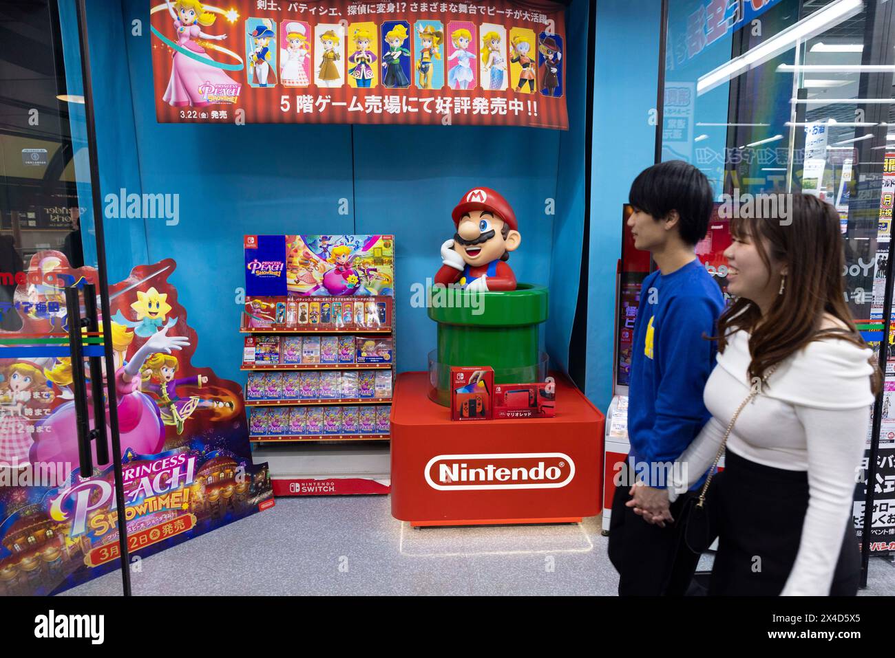 Osaka, Japan. 16th Apr, 2024. A couple walks past a Nintendo display ...