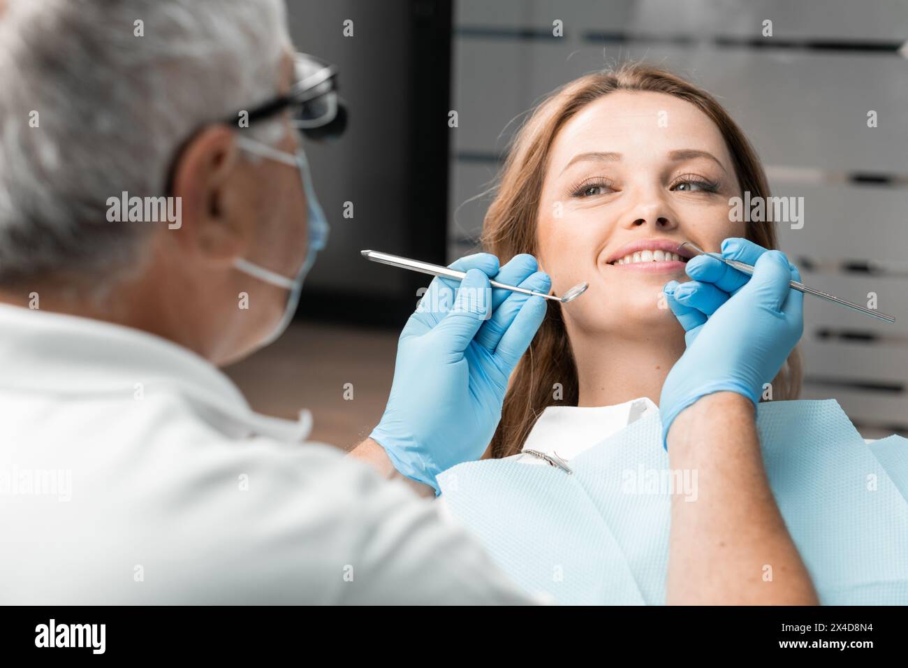 A patient in a dental chair happily reveals her beautiful smile made ...