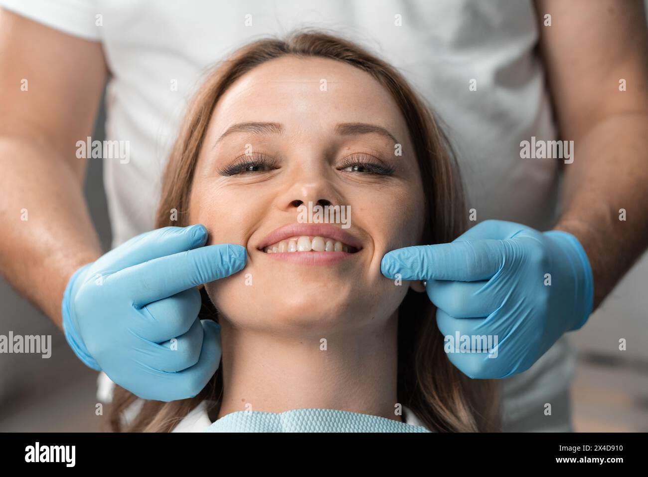 The patient sits comfortably in the dental chair, cheerfully showing ...