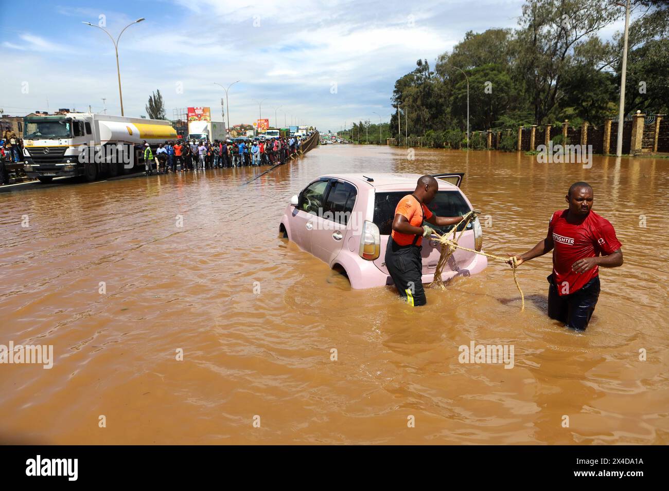 Nairobi, Kenya. 1st May, 2024. People pull a car submerged in flood ...