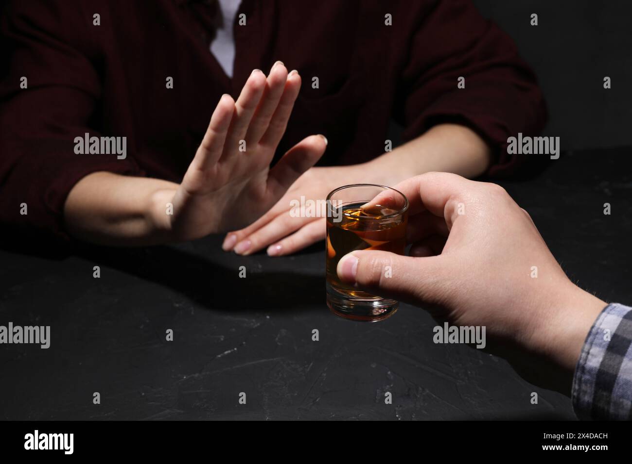 Alcohol addiction. Woman refusing glass of whiskey at dark table ...