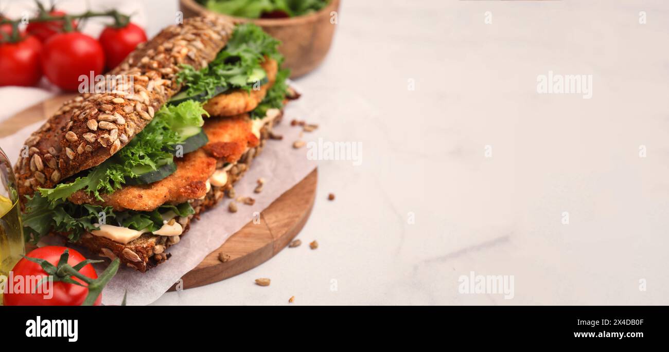 Delicious sandwich with schnitzel on white table, banner design. Space ...