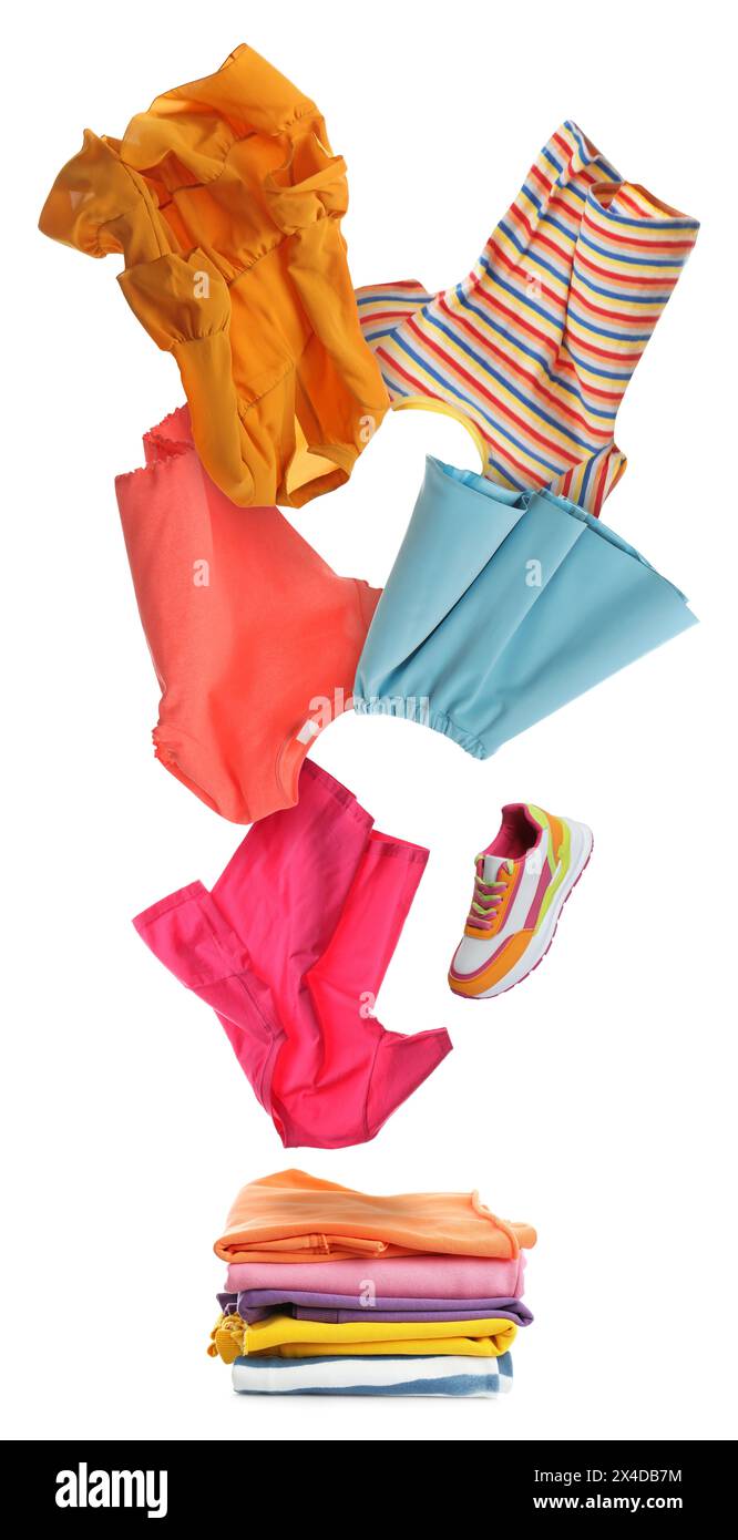 Laundry day. Different flying clothes over stacked ones on white ...