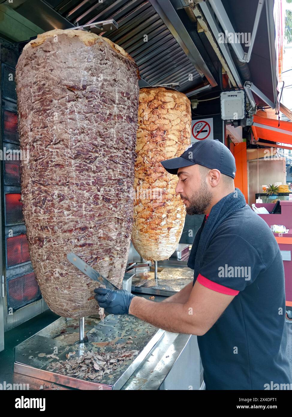 Kuala Lumpur, Malaysia - February 10, 2024: Cook slicing thin layers of ...