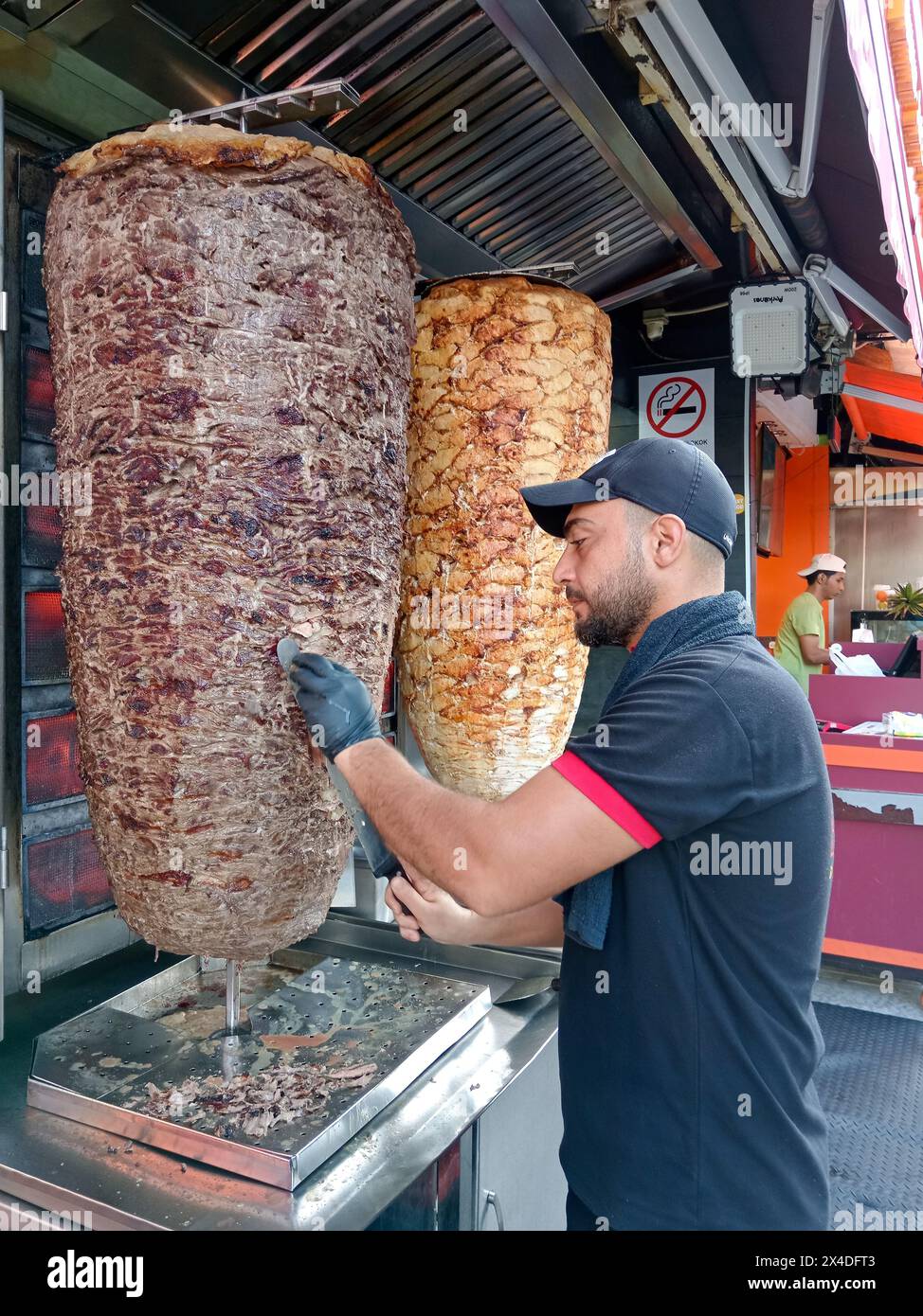 Kuala Lumpur, Malaysia - February 10, 2024: Cook slicing thin layers of ...