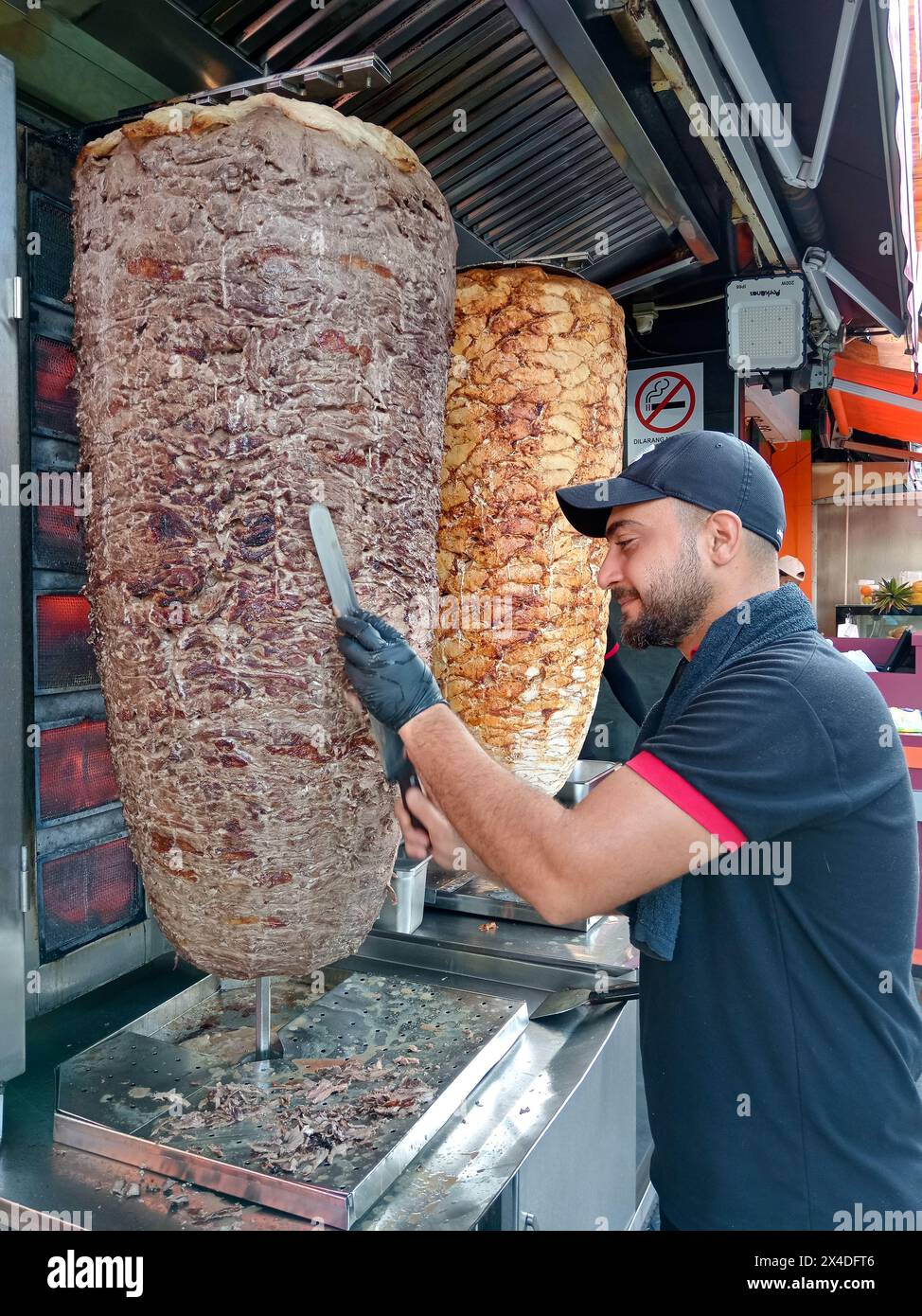 Kuala Lumpur, Malaysia - February 10, 2024: Cook slicing thin layers of ...
